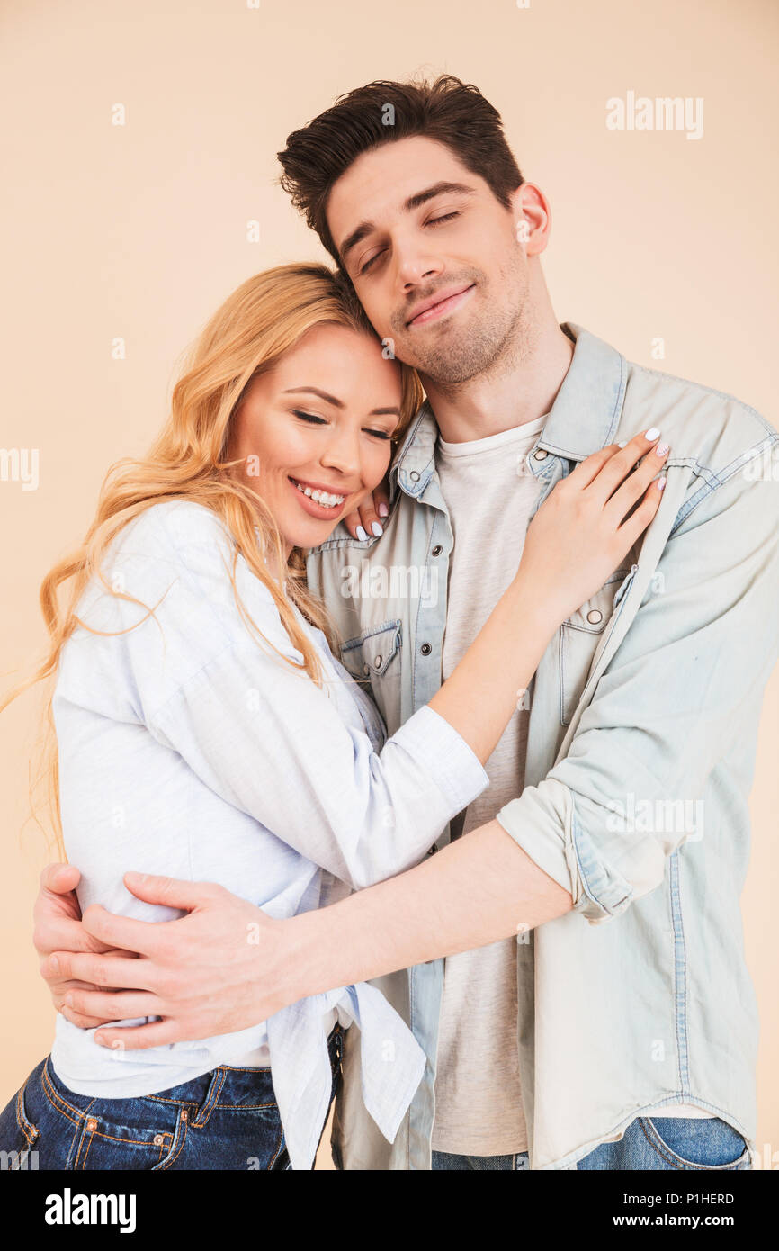 Portrait of happy couple man and woman in basic clothing hugging ...