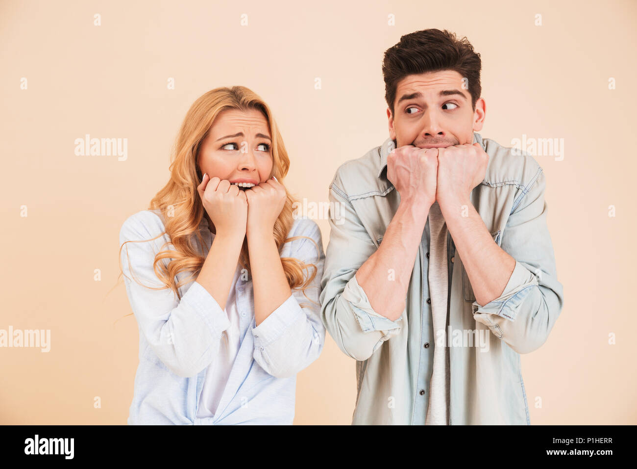 Image of scared man and woman in basic clothing looking at each other ...