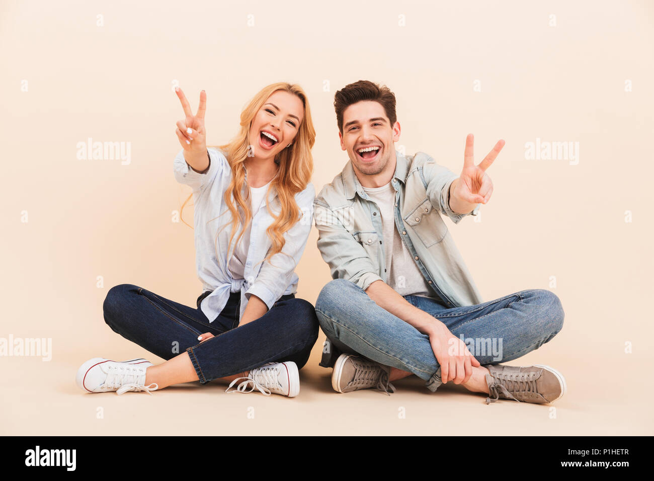 Image of happy two friends man and woman in casual clothing sitting on ...