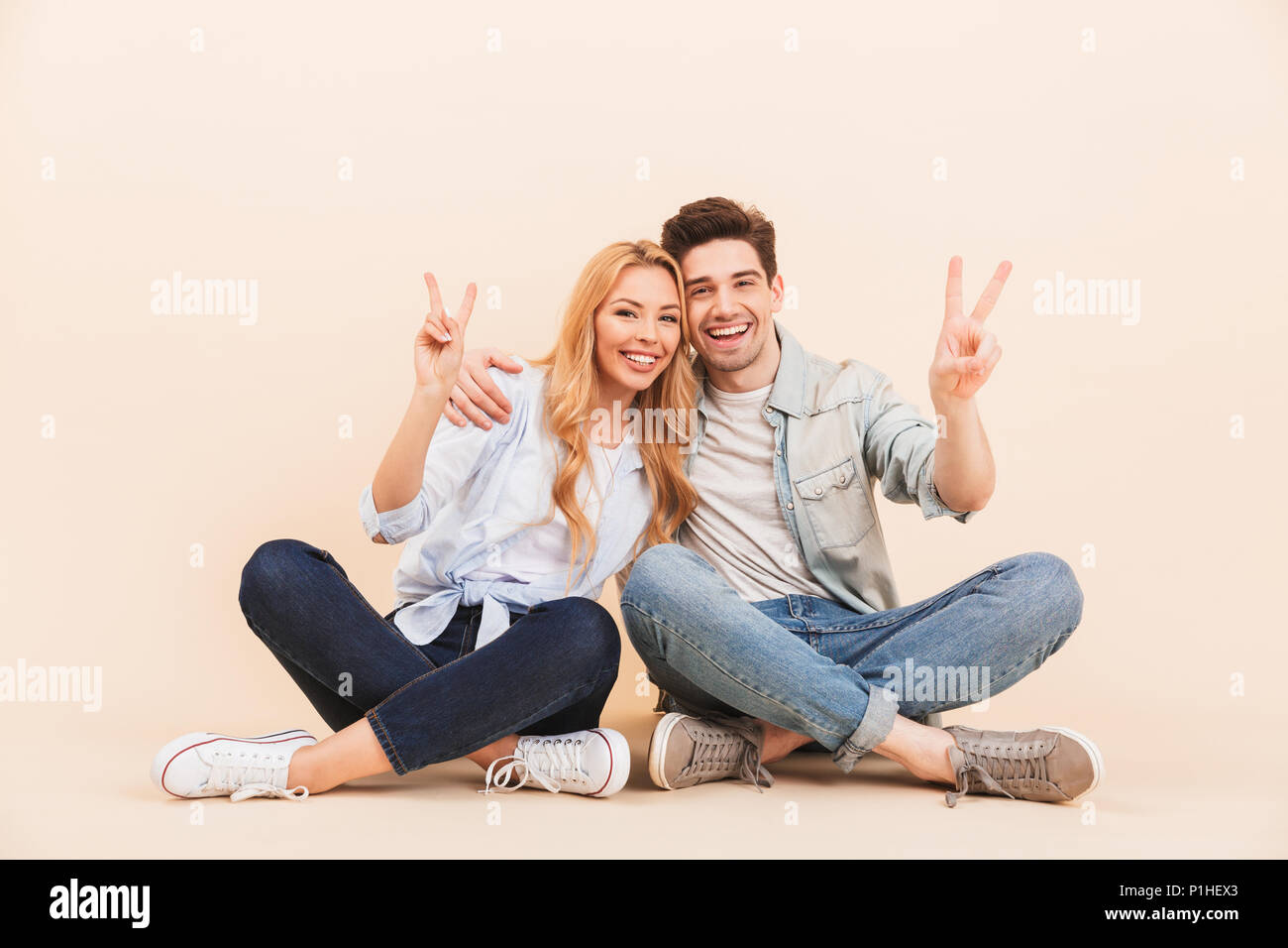 Image of pleased man and woman hugging together while sitting on the ...