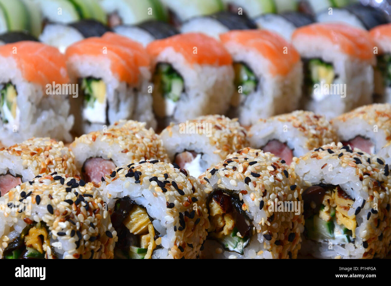 A macro shot of a sushi set of many rolls is located on a wooden ...