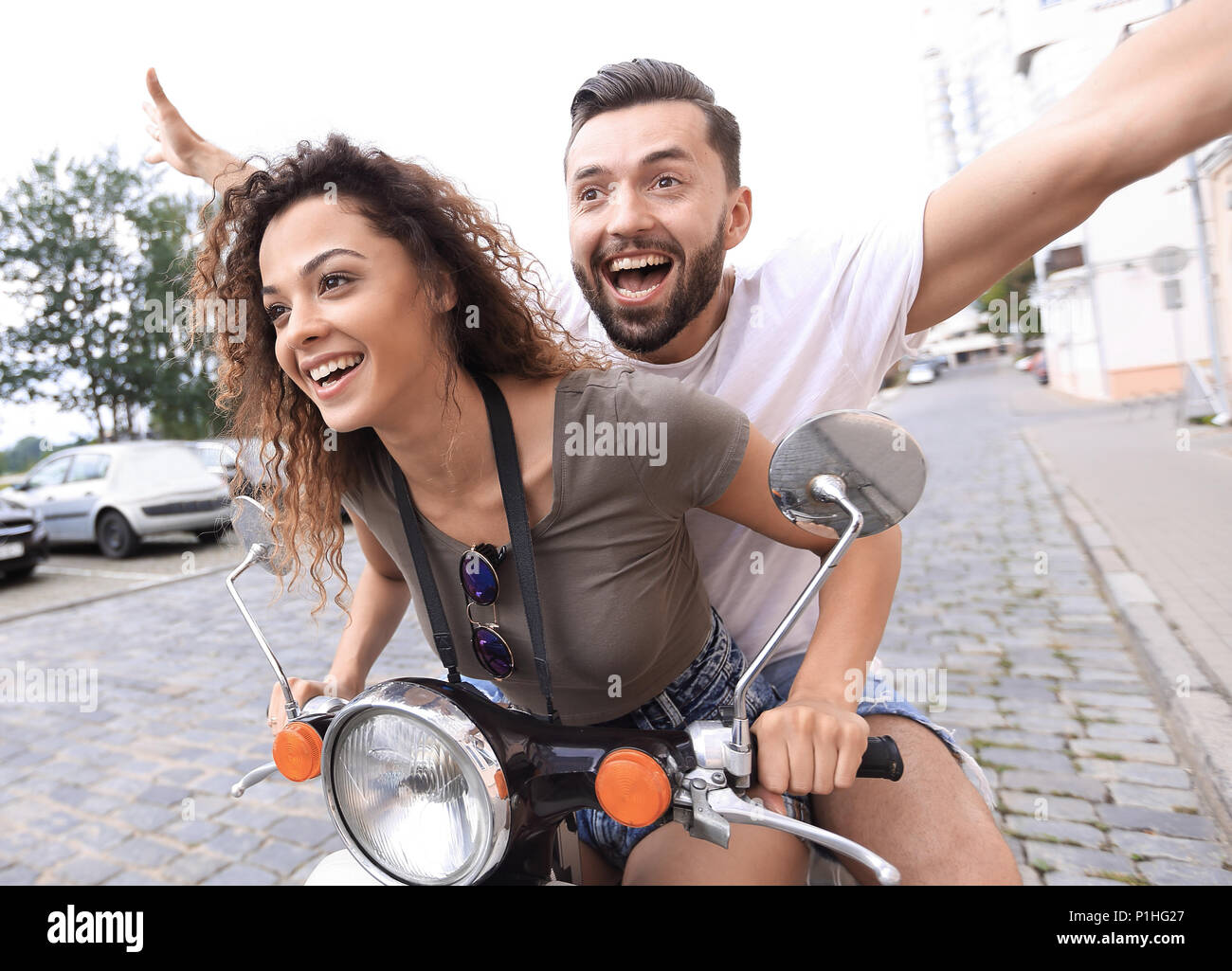 Couple riding motor scooter in old city street Stock Photo - Alamy
