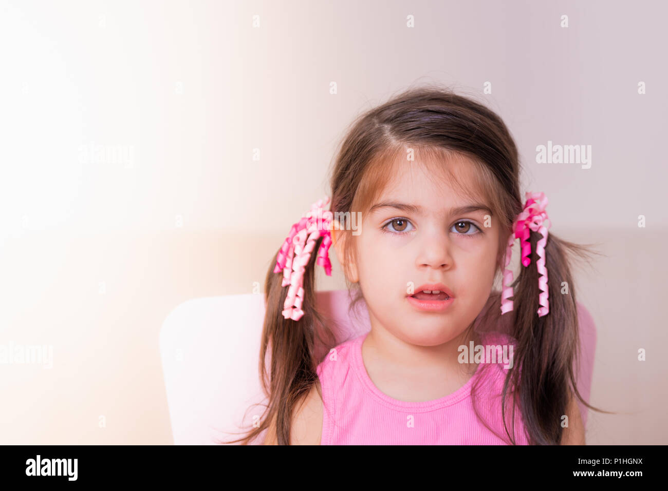 Portrait view of cute girl with confused expression on her face ...