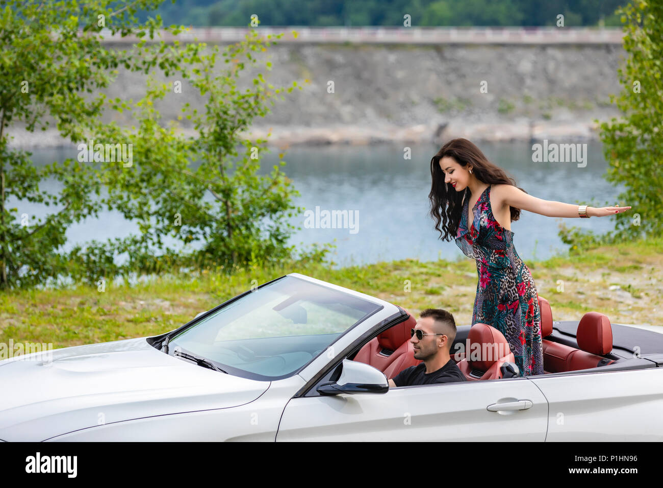 Couple in convertible. Happy young couple enjoying road trip in their ...
