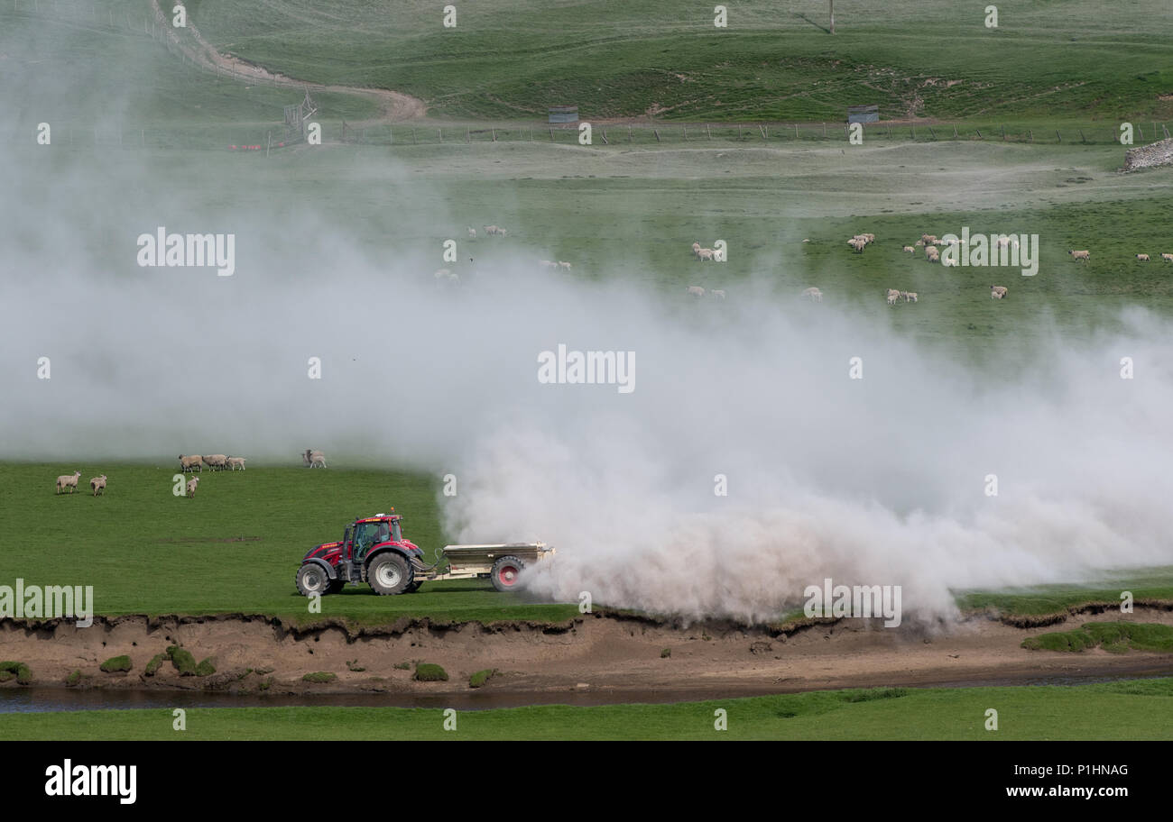 Contractor spreading lime on pastures to improve soil quality, in ...