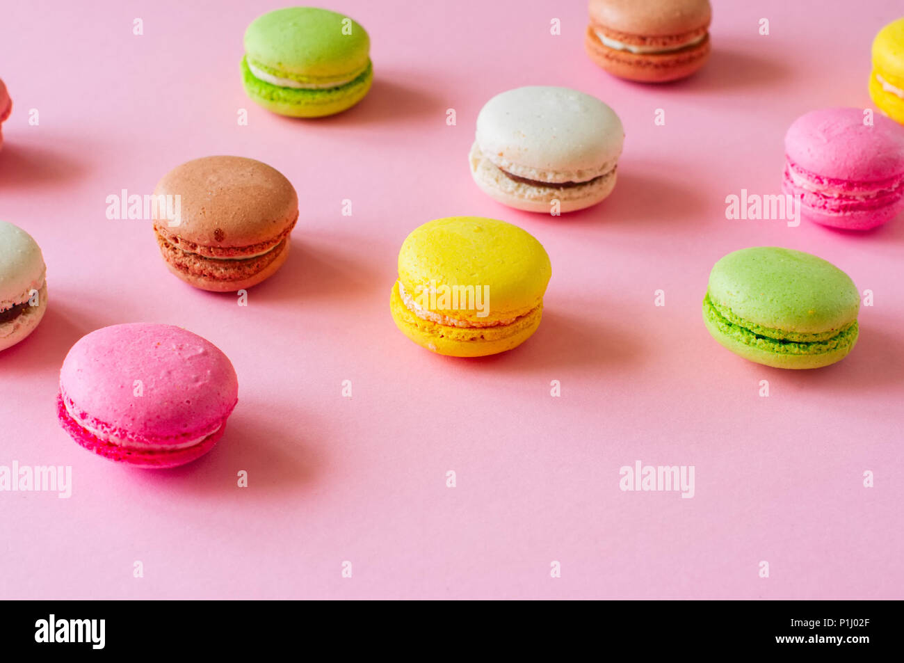 Colorful macarons- french cookies on a pink background. Top view Stock ...