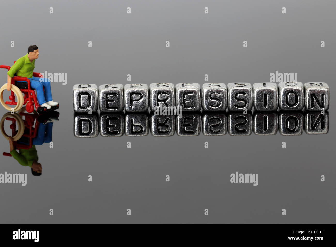 Miniature scale model man in a wheelchair with the word depression on ...