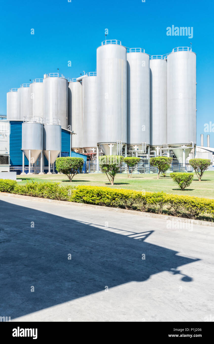 Beverage factory cylinders. With blue sky Stock Photo - Alamy