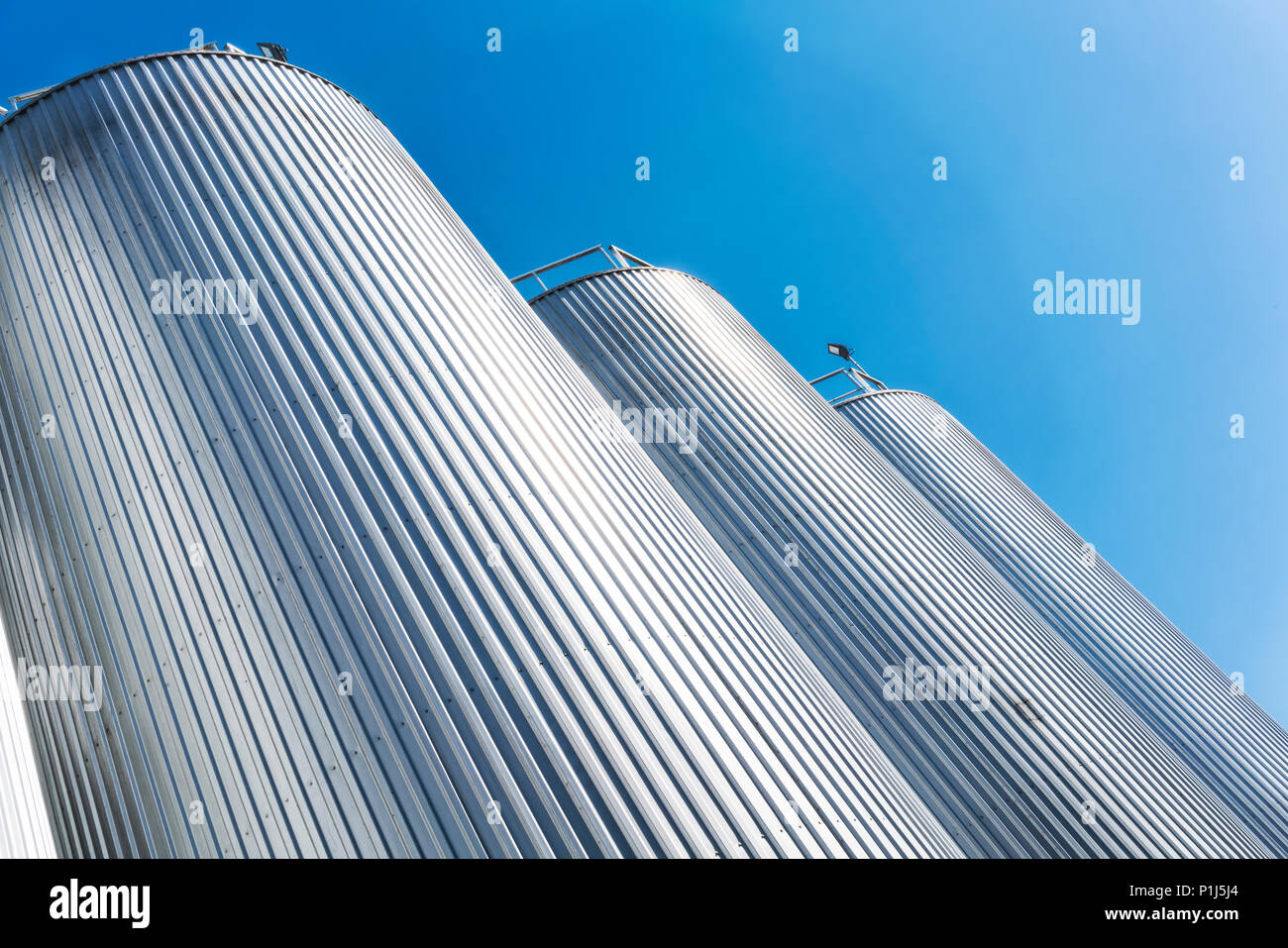 Beverage factory cylinders. With blue sky Stock Photo - Alamy