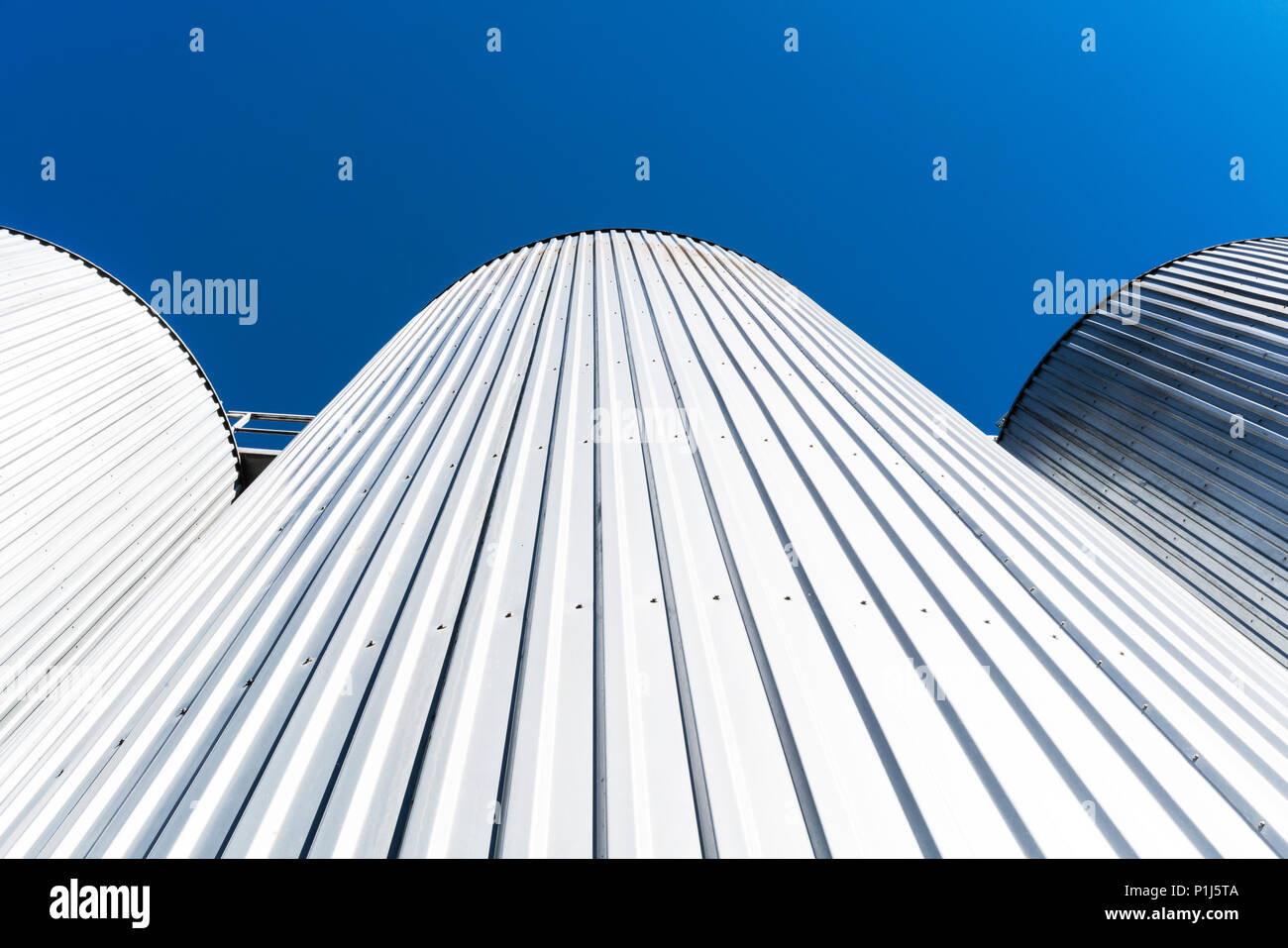 Beverage factory cylinders. With blue sky Stock Photo - Alamy