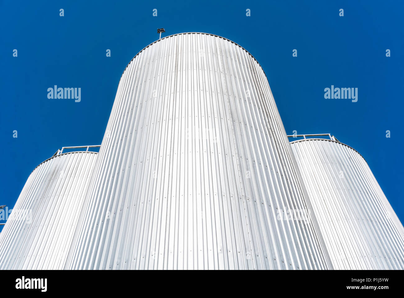 Beverage factory cylinders. With blue sky Stock Photo - Alamy