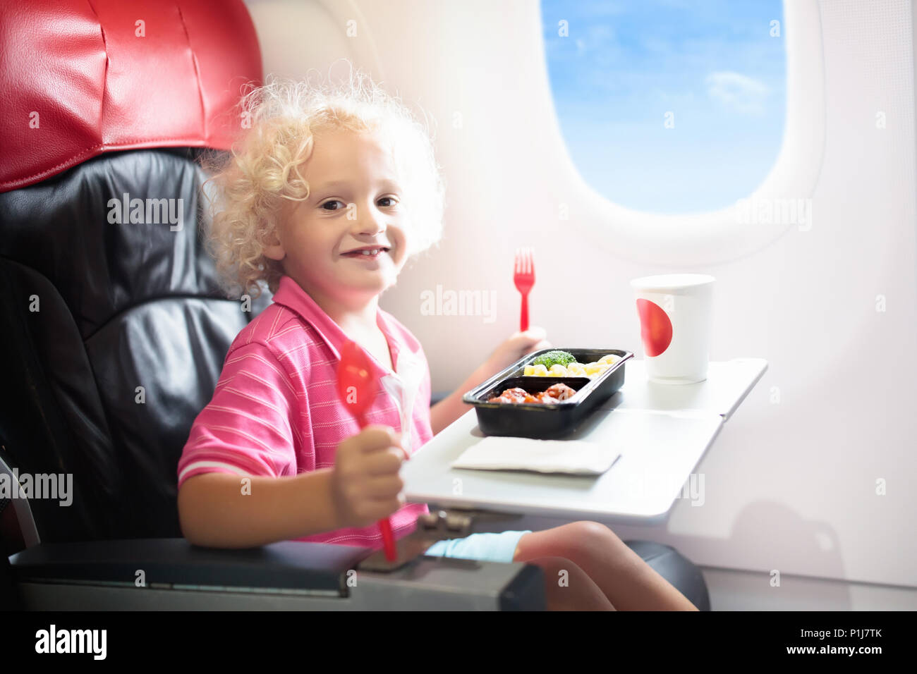 Child in airplane window seat. Kids flight meal. Children fly. Special ...