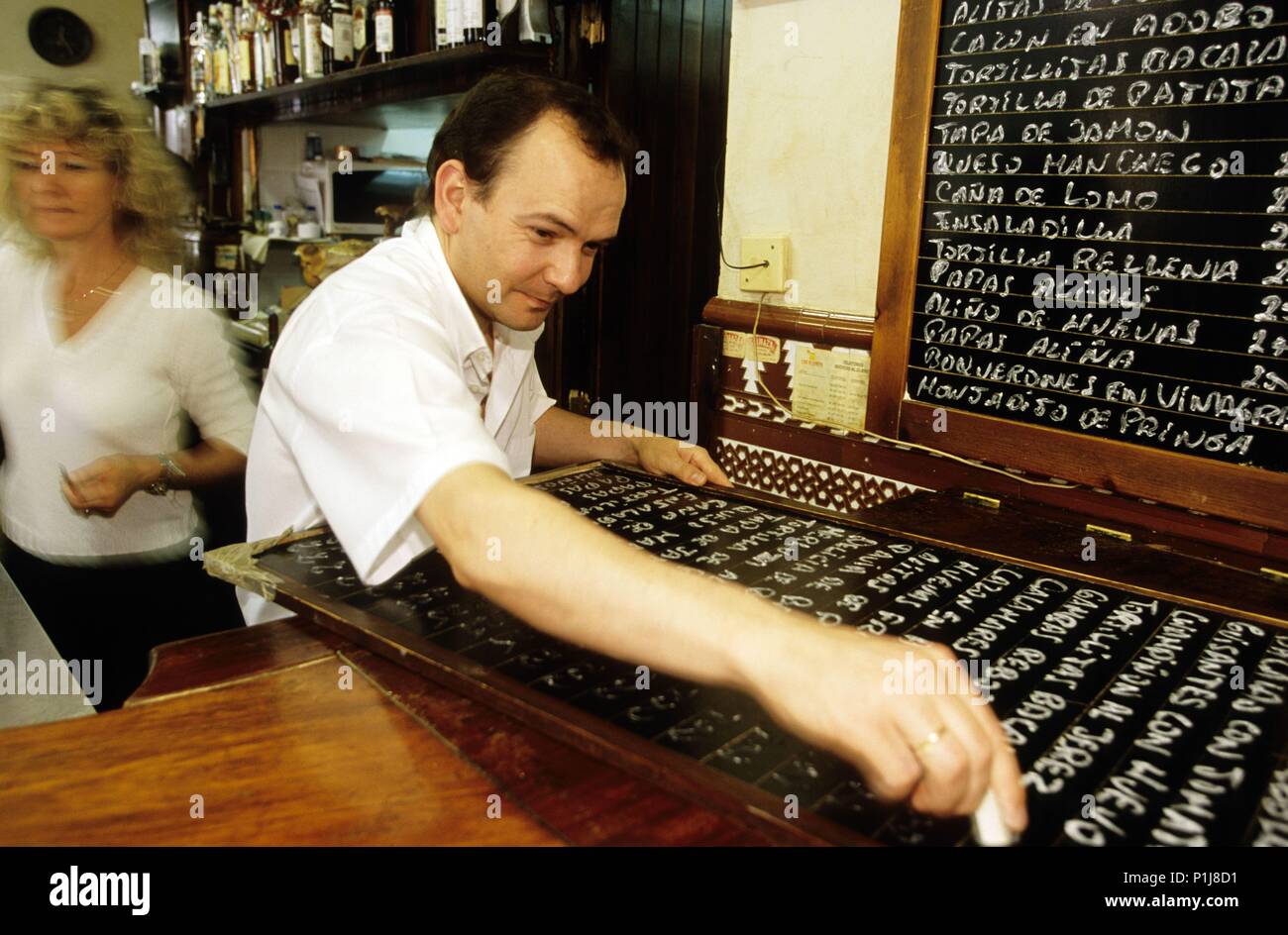traditional "Las Columnas" bar; waiter writing the "tapas" (typical ...
