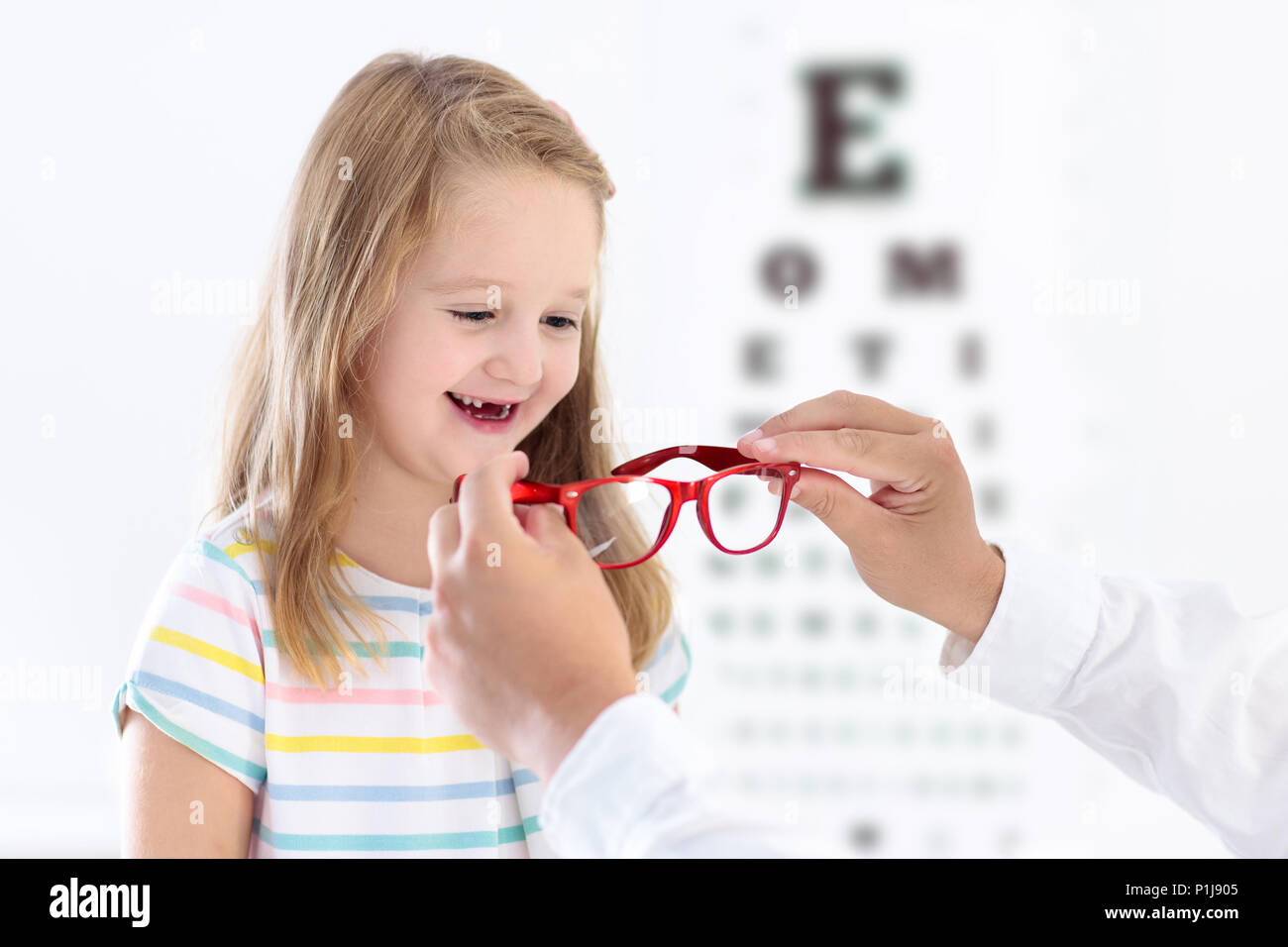 Child at eye sight test. Little kid selecting glasses at optician store ...