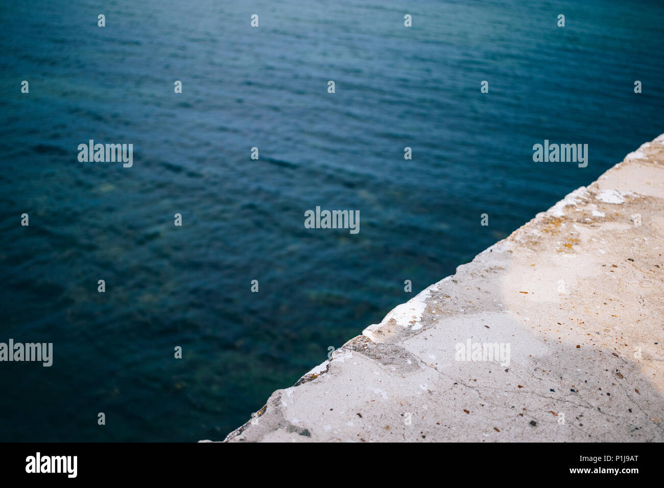 Close-up part of the concrete pier and water surface. Sea view from the ...
