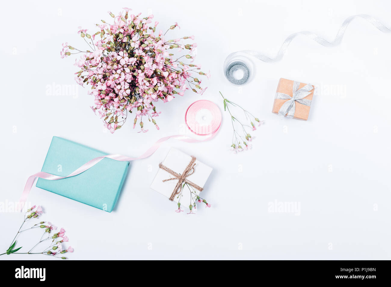 Feminine festive pink flat layout with bouquet, ribbons and gift boxes ...