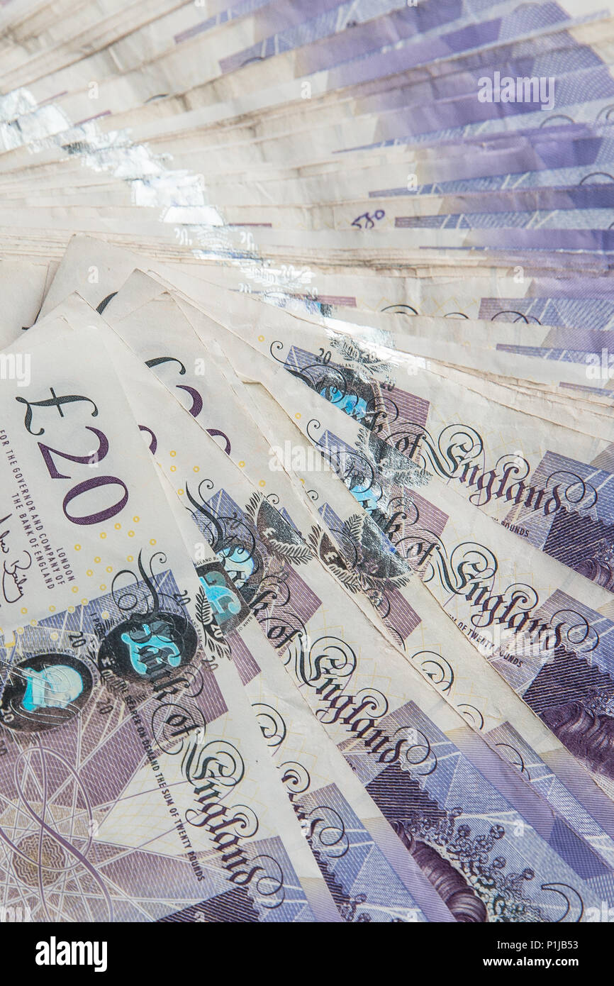 A pile of British twenty pound notes on a white paper background Stock ...