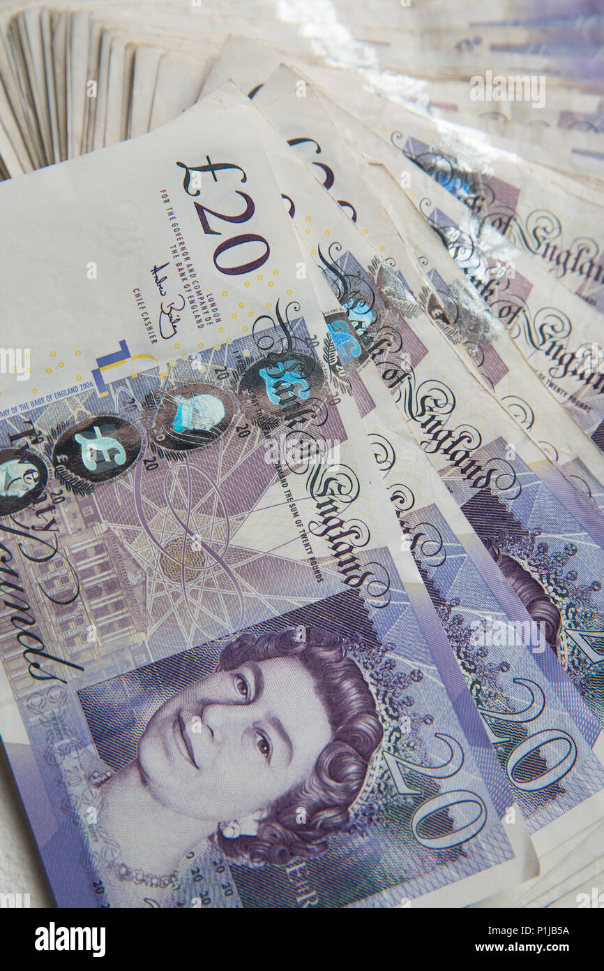 A pile of British twenty pound notes on a white paper background Stock ...