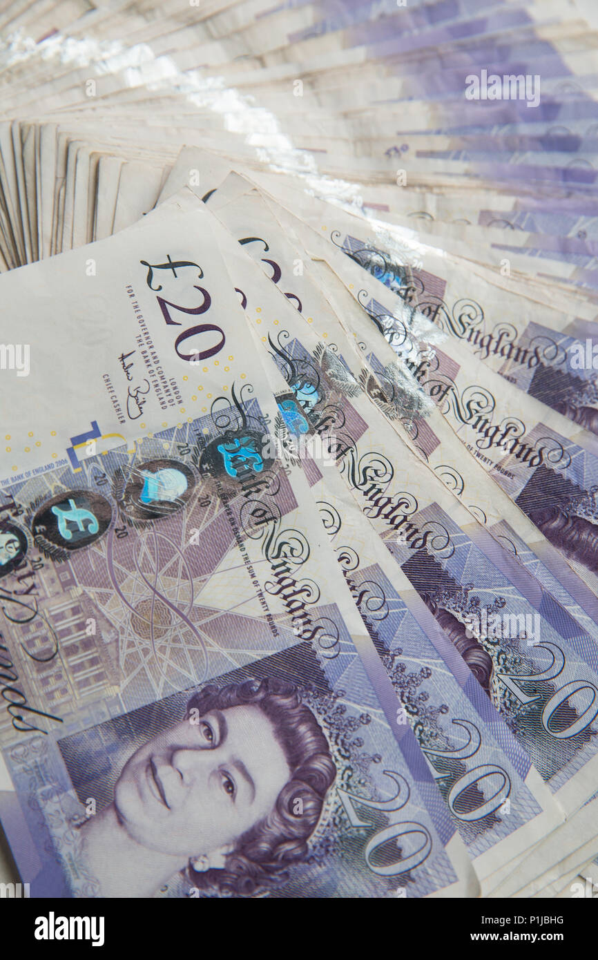A pile of British twenty pound notes on a white paper background Stock ...