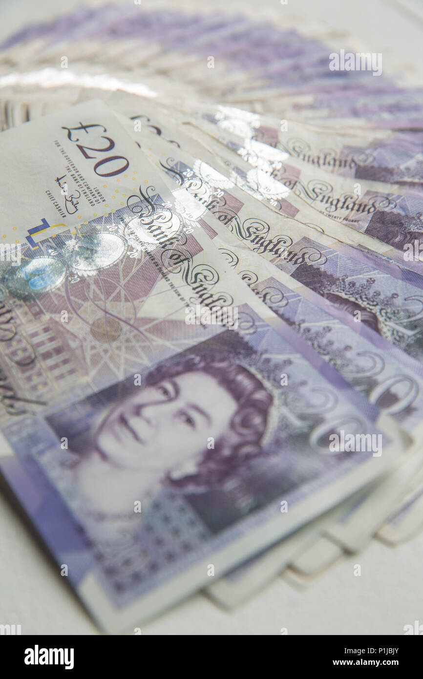 A pile of British twenty pound notes on a white paper background Stock ...