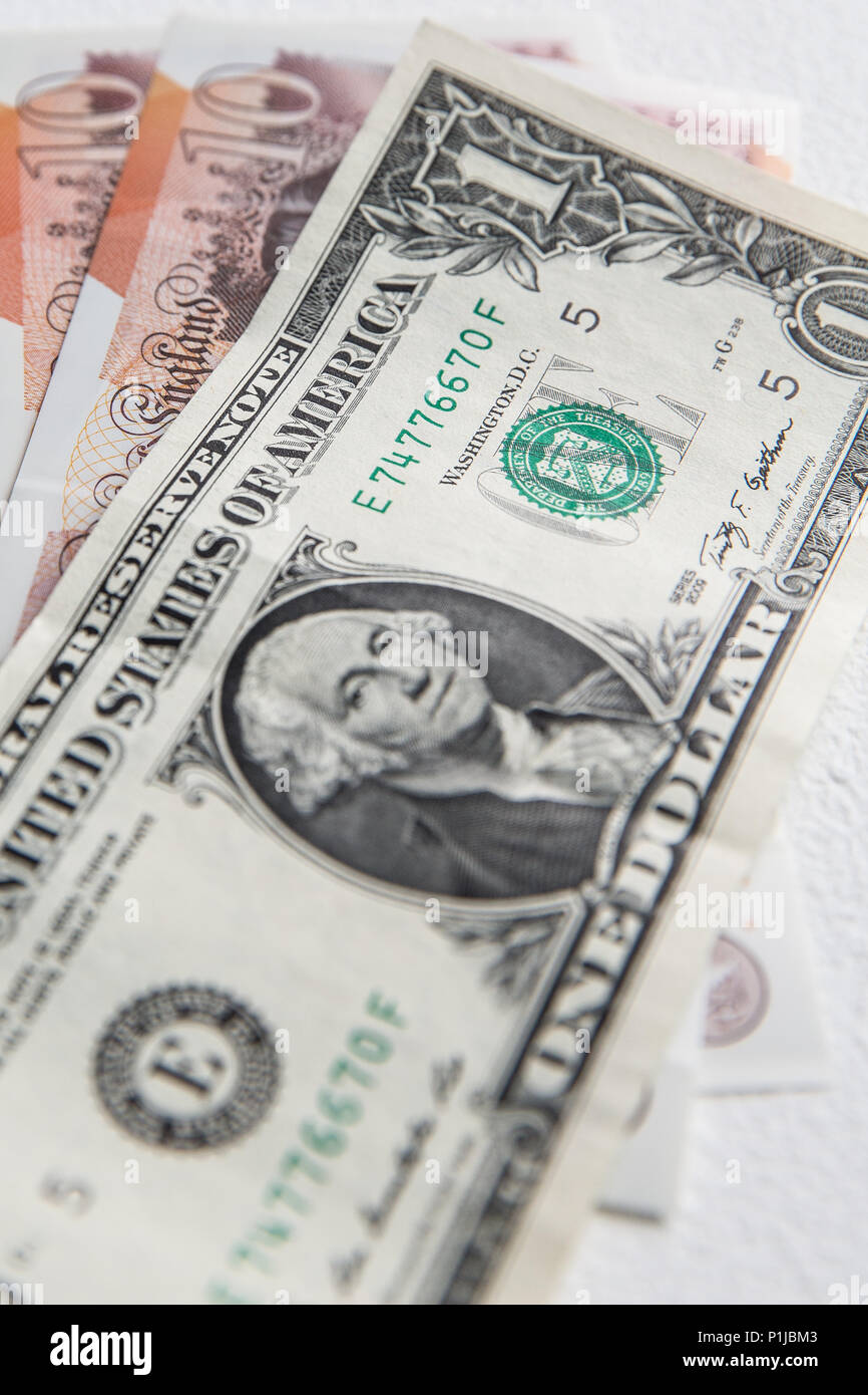 A pile of US one dollar notes and English ten pound notes in a pile on ...