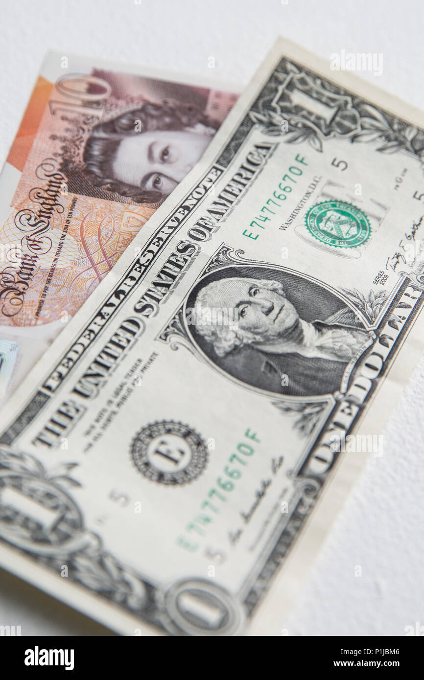 A pile of US one dollar notes and English ten pound notes in a pile on ...