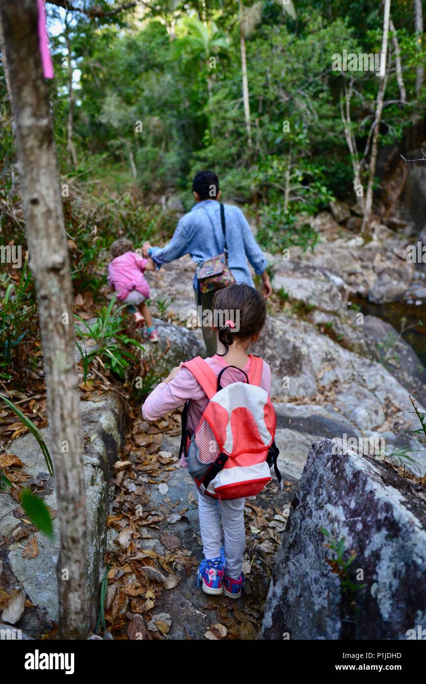 Mother helps daughters through a rocky outcrop while walking through a ...