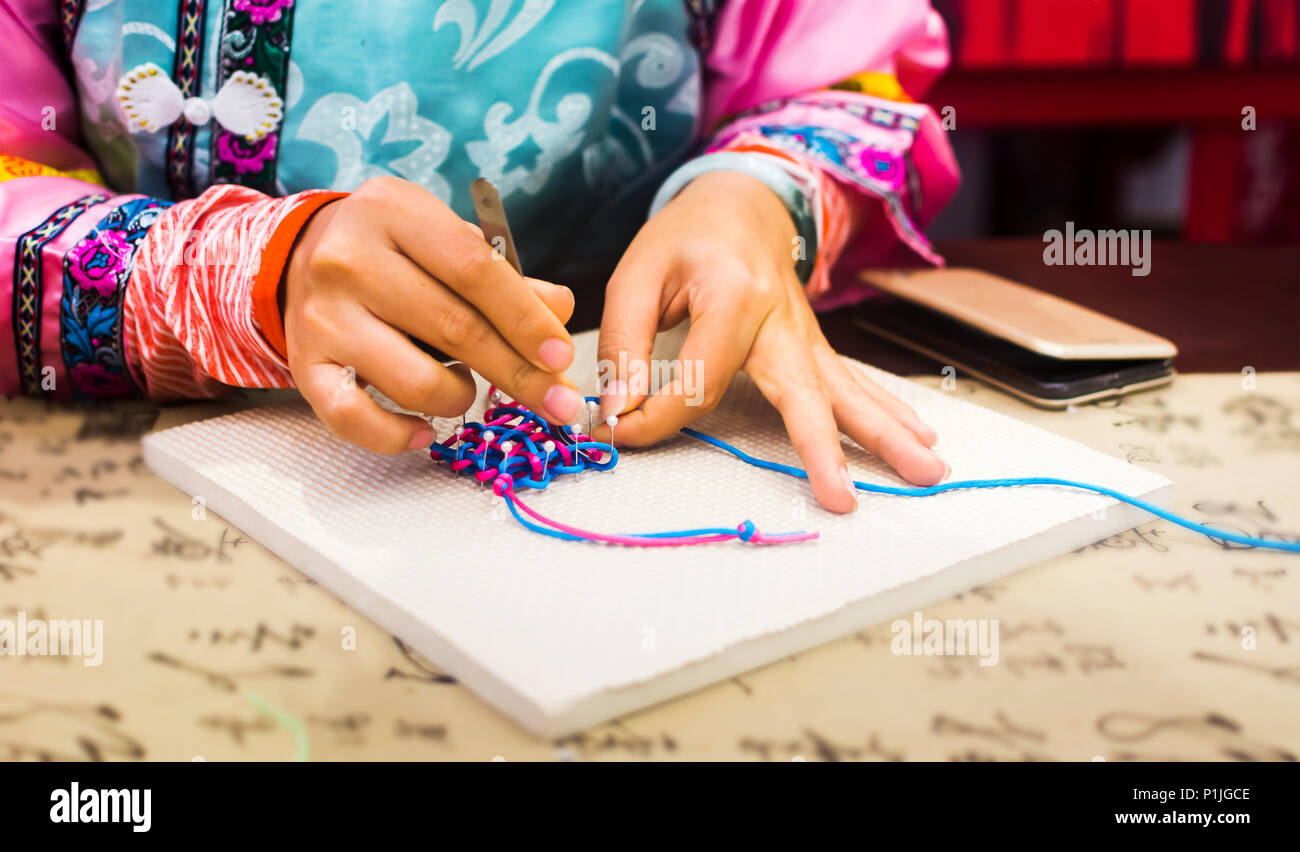 Woman making traditional Chinese knot close up Stock Photo - Alamy