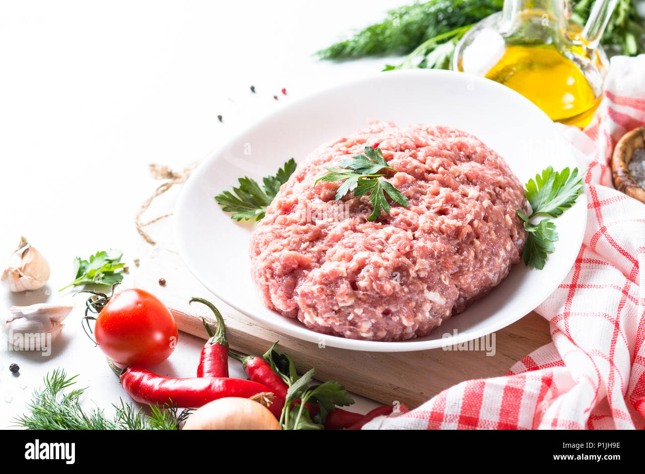 Minced meat with ingredients for cooking on white table Stock Photo - Alamy