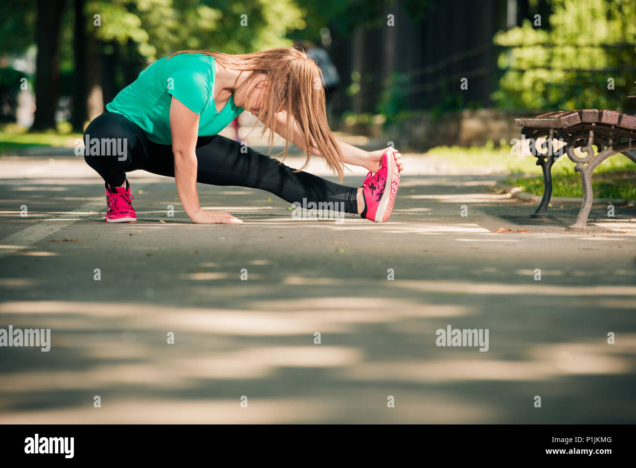 Flexible young woman stretching her left leg Stock Photo - Alamy