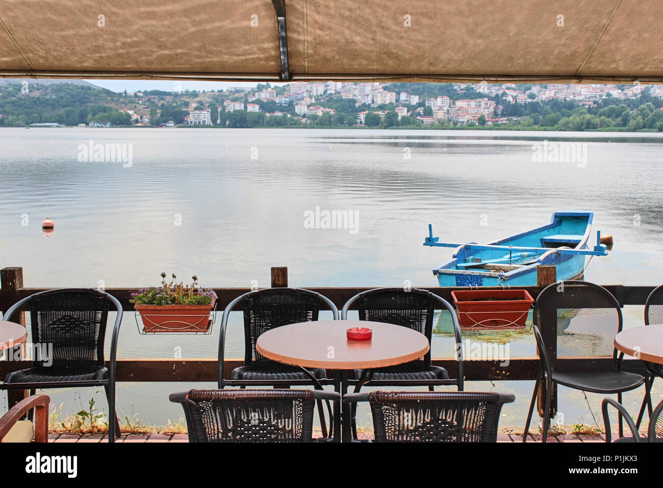 Lake view from a quiet Cafe with a blue boat in front Stock Photo - Alamy