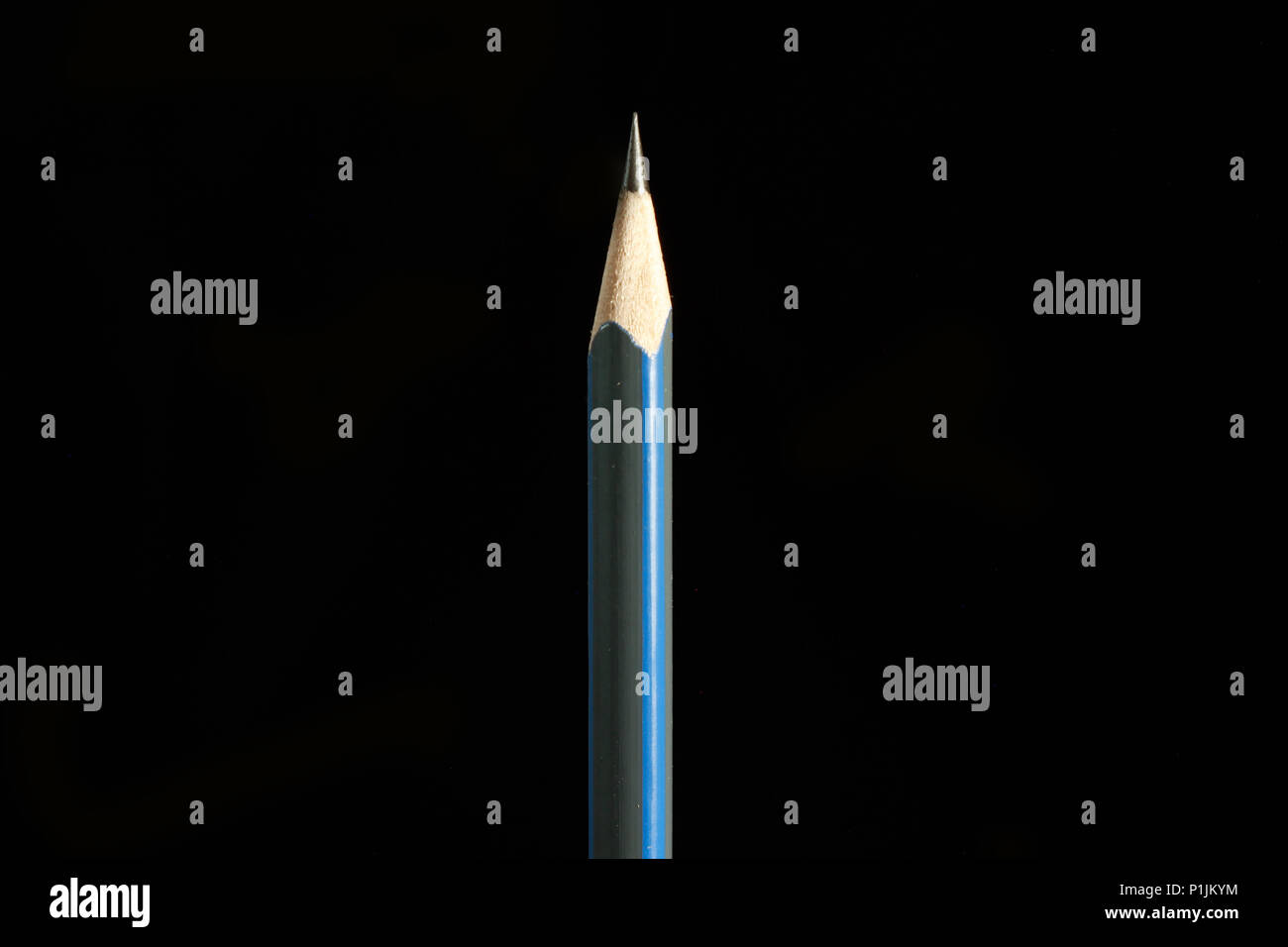 Vertical pencil on a black background Stock Photo - Alamy