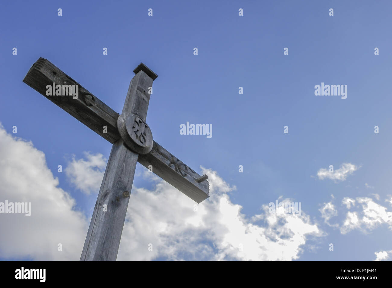 Magnificent low angle shot of a wooden cross with blue sky background ...