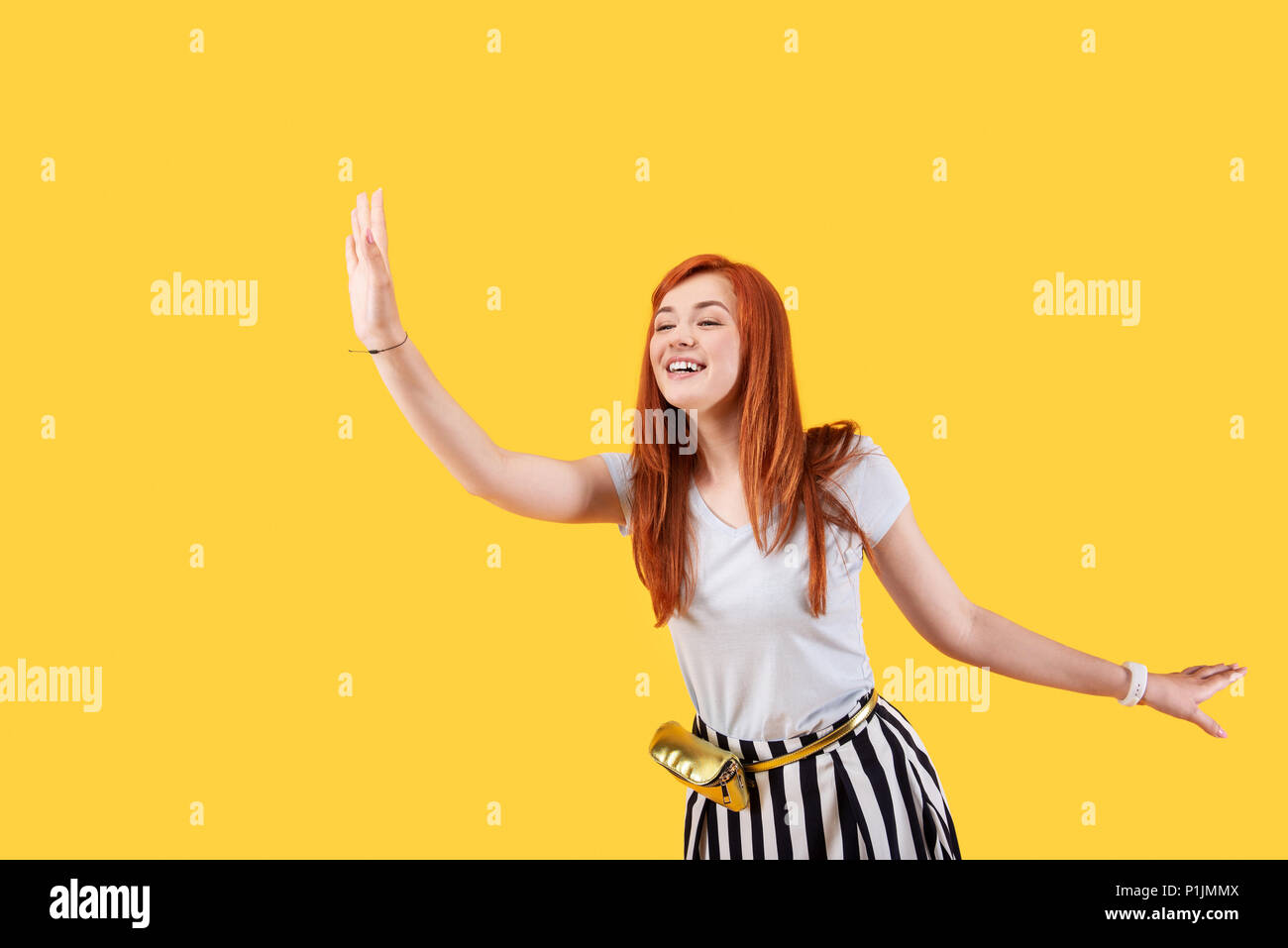 Nice positive woman standing against yellow background Stock Photo - Alamy