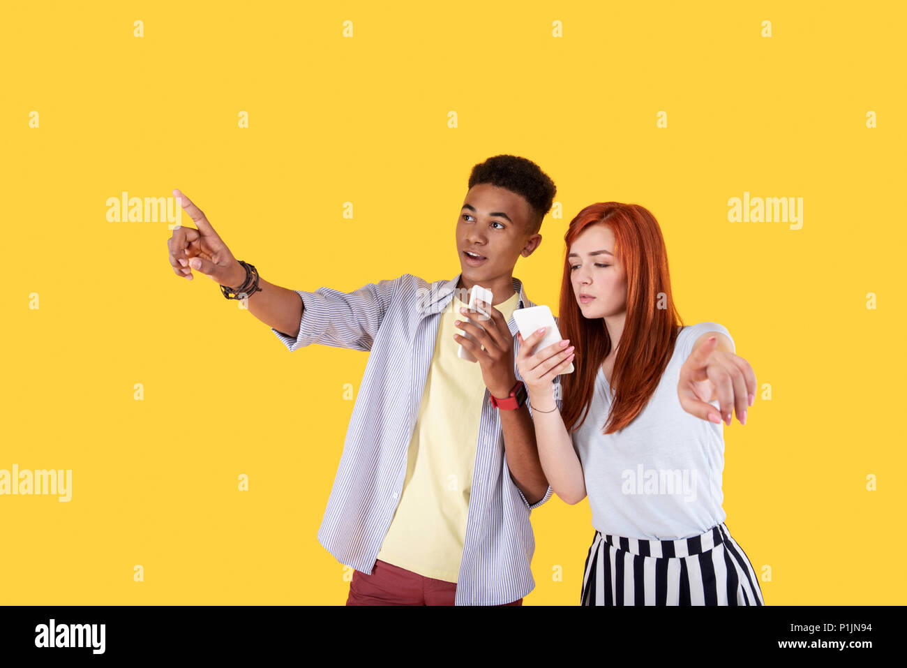 Nice young people pointing at different directions Stock Photo - Alamy