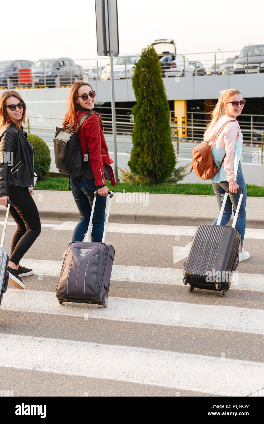 Photo of three happy girls smiling while traveling abroad together ...