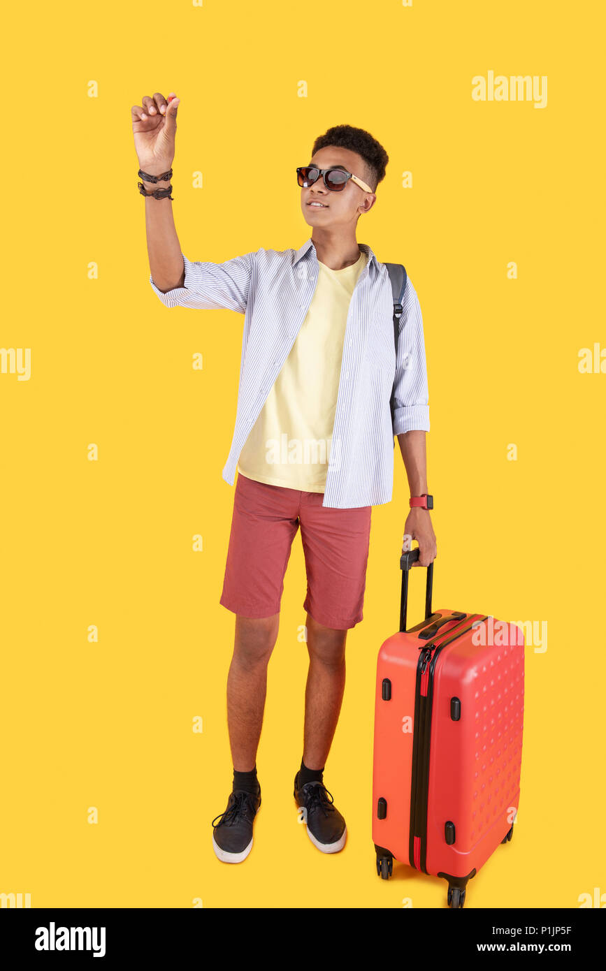 Nice young man holding his suitcase Stock Photo - Alamy