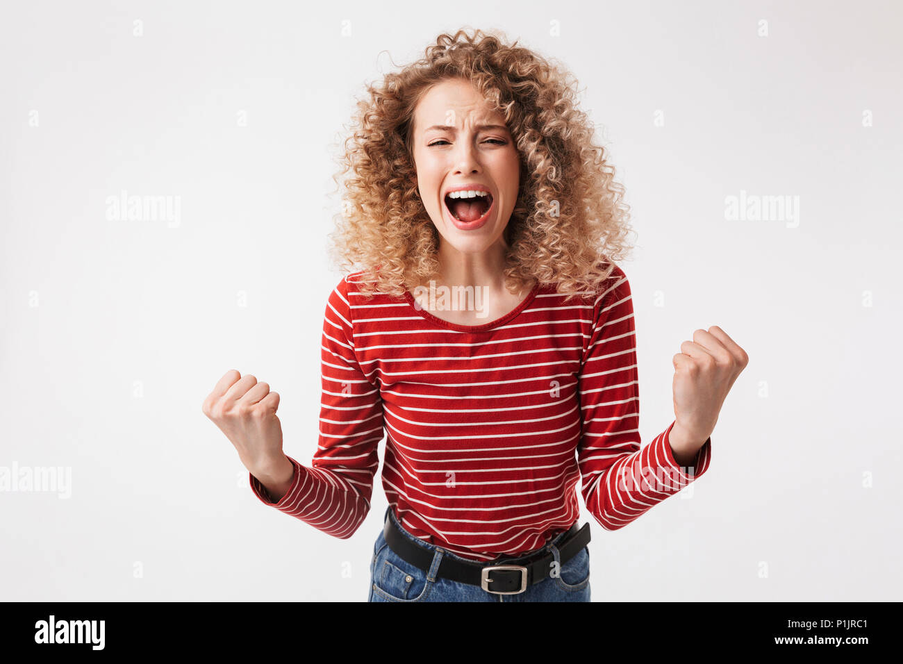 Portrait of angry young girl with curly hair screaming isolated over ...