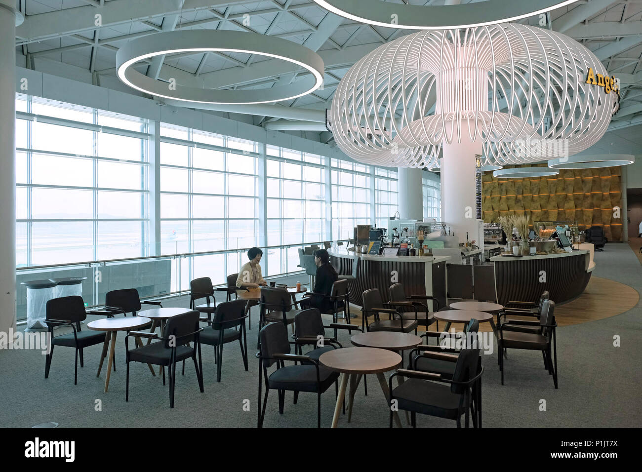 Passengers sit in a cafe in terminal 2 at Incheon International Airport ...