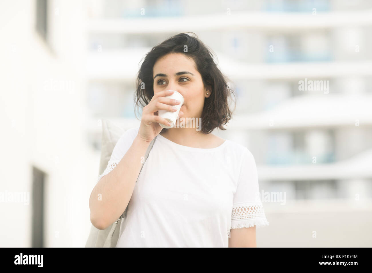 Woman standing outdoors drinking water Stock Photo - Alamy