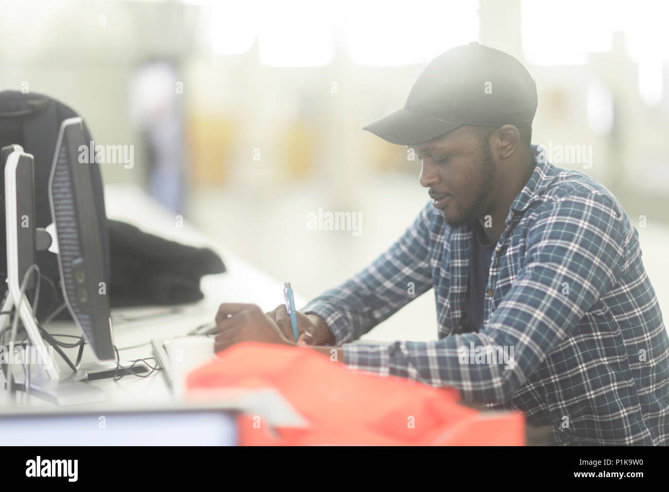 Man sitting at desk working with a safety vest next to him Stock Photo ...