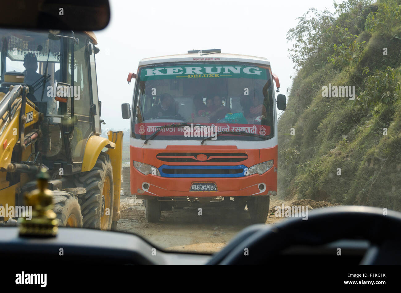 Bus passing excavator on narrow road, Rural traffic jam, Trishuli ...
