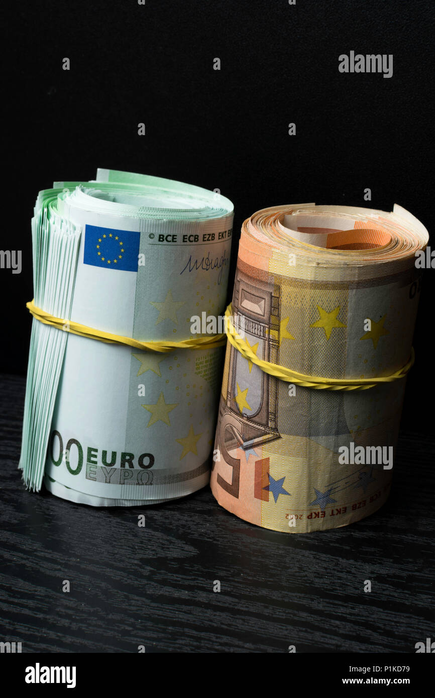 Rolled several thousand euro banknotes with rubbers Stock Photo - Alamy