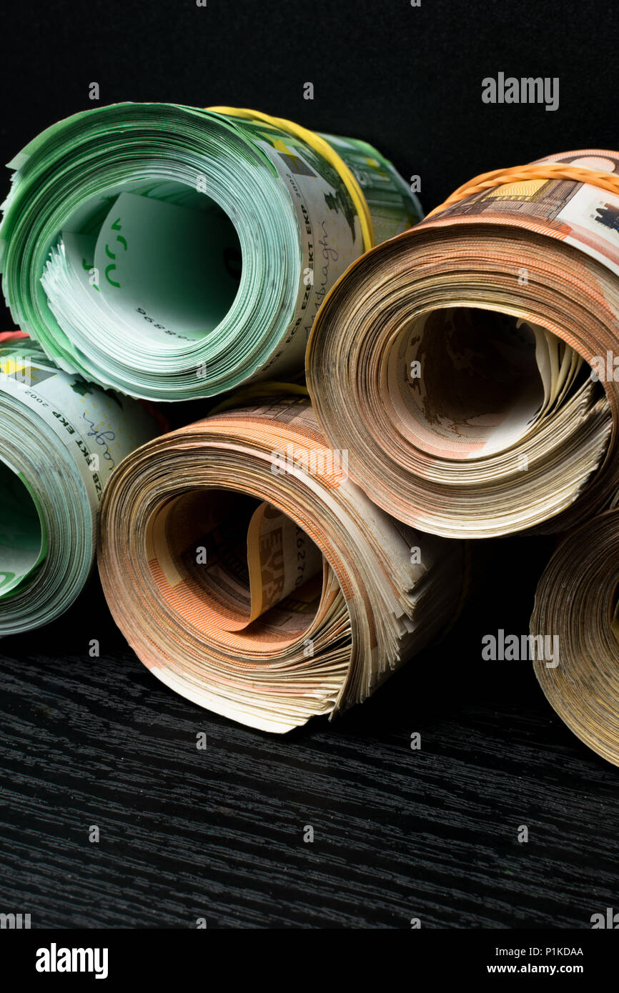 Rolled several thousand euro banknotes with rubbers Stock Photo - Alamy