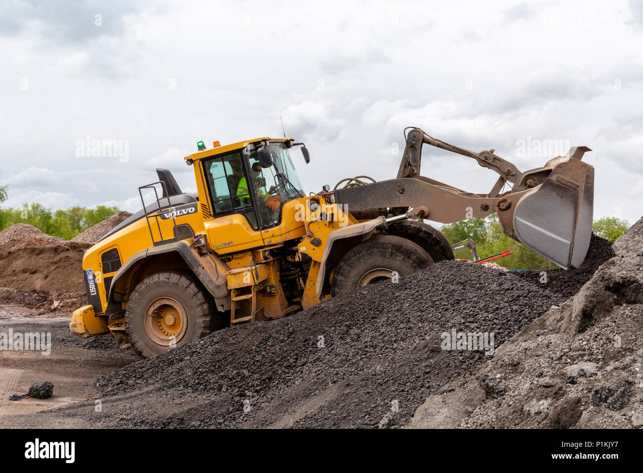 A Wheel Loader Vehicle Moving a Large Pile of Gravel and Asphalt on ...