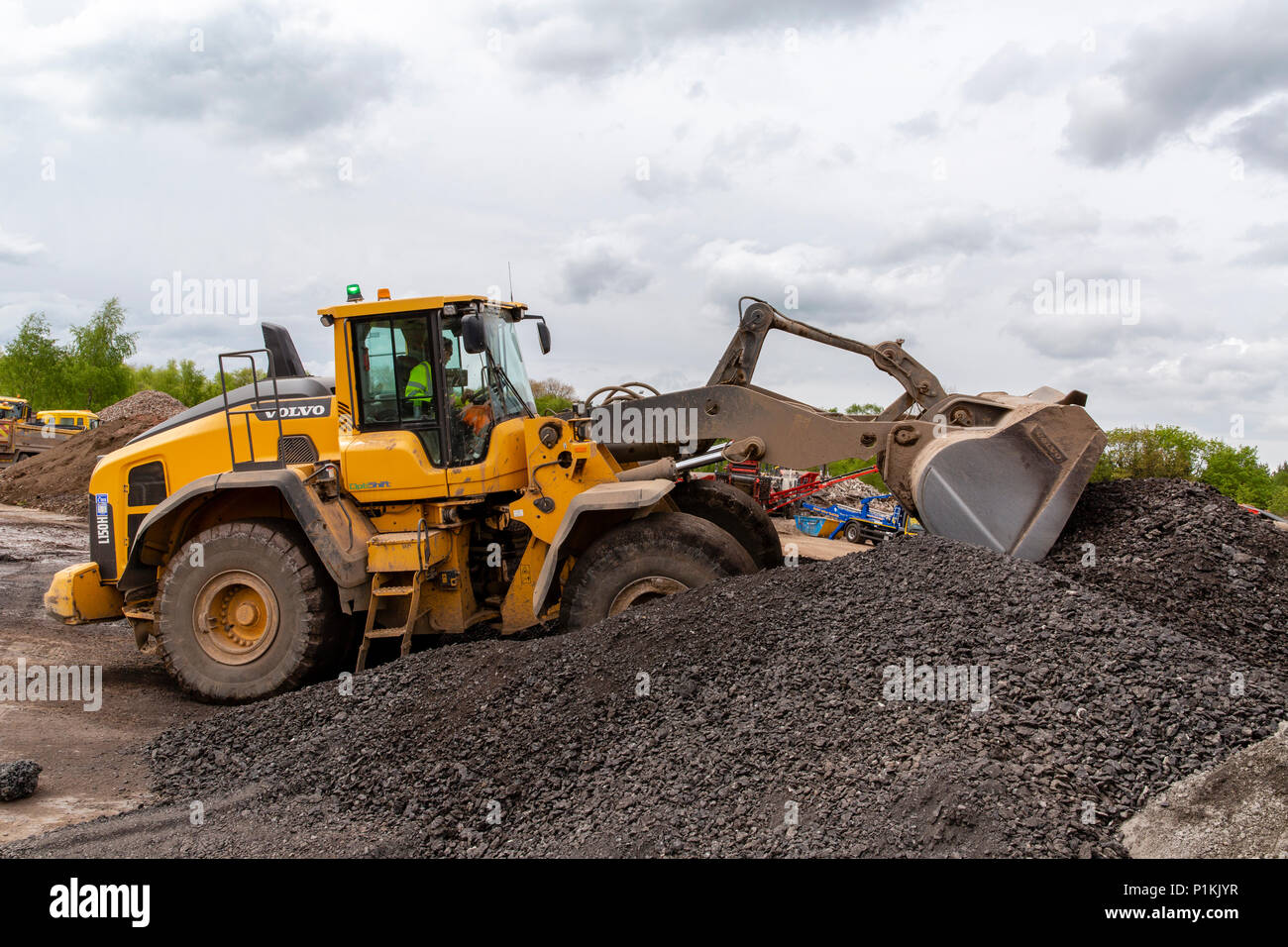 A Wheel Loader Vehicle Moving a Large Pile of Gravel and Asphalt on ...