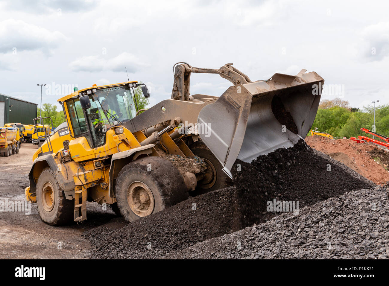 A Wheel Loader Vehicle Moving a Large Pile of Gravel and Asphalt on ...