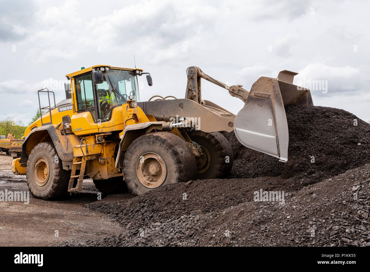 A Wheel Loader Vehicle Moving a Large Pile of Gravel and Asphalt on ...