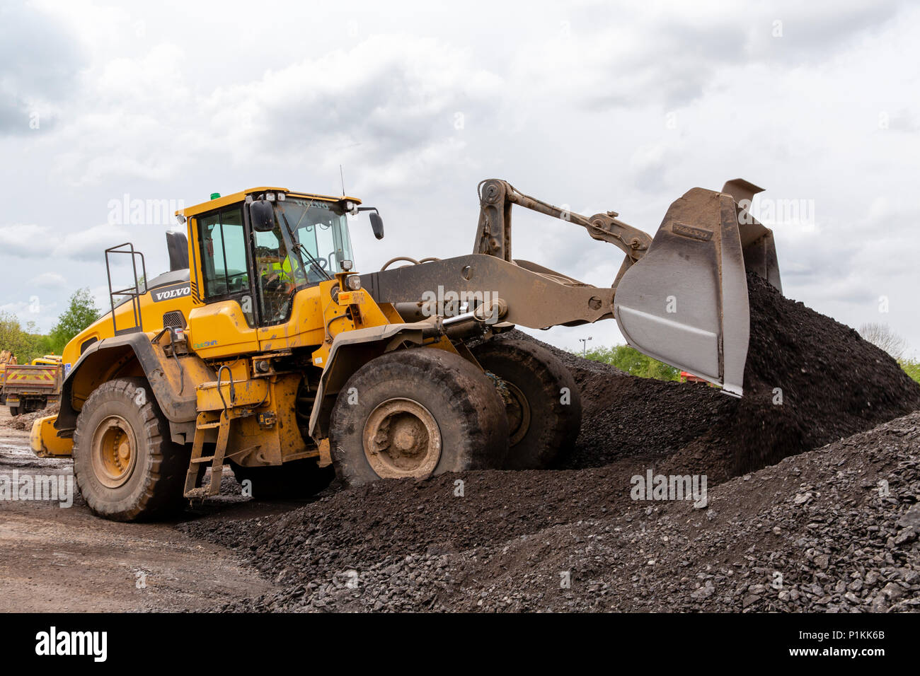 A Wheel Loader Vehicle Moving a Large Pile of Gravel and Asphalt on ...