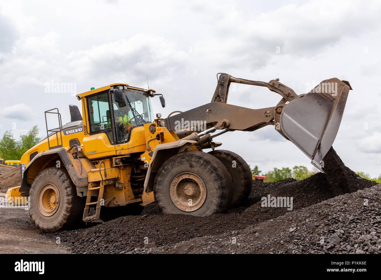 A Wheel Loader Vehicle Moving a Large Pile of Gravel and Asphalt on ...